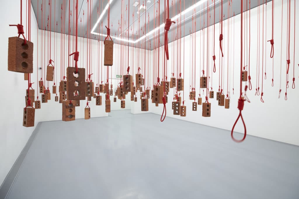 Kendell Geers. Hanging Piece. 1993. Brick, rope and metal hooks ...